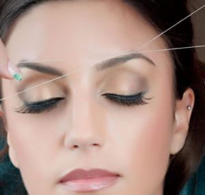 Plucking eyebrows with thread and thread technique